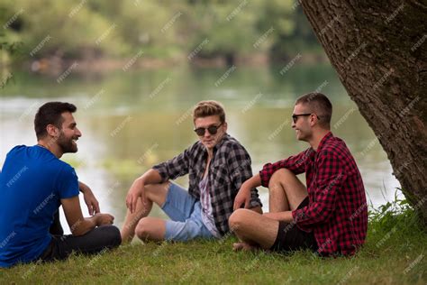Premium Photo Group Of Young Men Enjoying The Nature Sitting On The