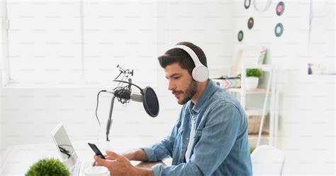 블로거와 라디오 진행자가 스마트폰을 보고 라이브 쇼 중에 팬과 청중의 댓글과 질문을 읽는 프로필 보기 사진 Unsplash의 사람 이미지