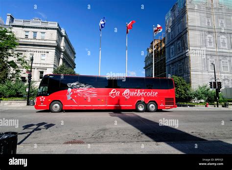 A Red Quebec Tour Bus Passing The Montreal City Hall On Rue Notre Dame