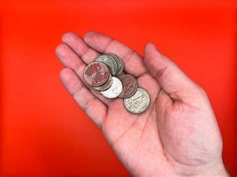 Male Hand Holding Us Cents In Palm On Bright Red Background Top View
