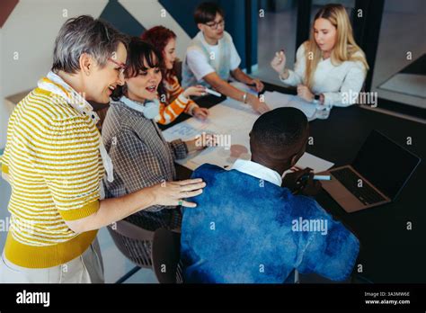 A Teacher Guides A Diverse Group Of Pupils During A Collaborative