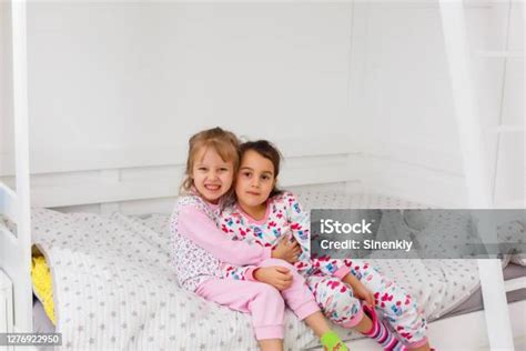Dua Adik Kecil Tersenyum Indah Di Tempat Tidur Putih Atas Melihat Foto