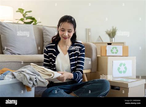 Young Woman Volunteer To Recycle Clothes At Home Sorting Donation For