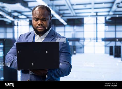 Engineer In Server Room Using Laptop To Implement And Maintain Security