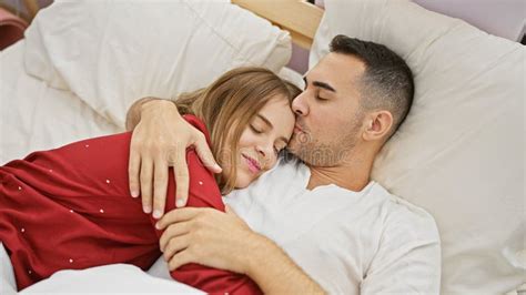 A Loving Couple Cuddles In Bed Portraying Intimacy And Fondness Within