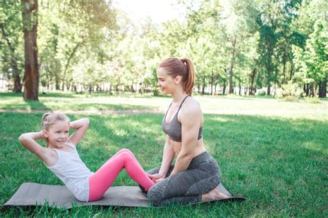 Premium Photo Two Girls Are Excercising In Park Woman Is Sitting On