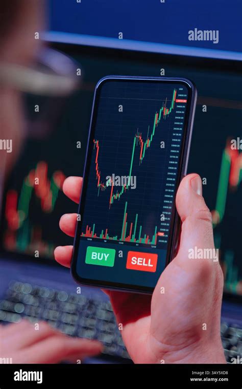 Over The Shoulder View Of A Trader Closely Examining Cryptocurrency Charts On A Smartphone Via A