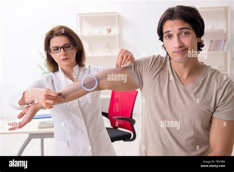 Female Doctor Checking Patients Joint Flexibility With Goniometer