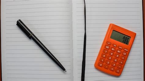 Premium Photo Table Layout With Notebook Calculator And Pen