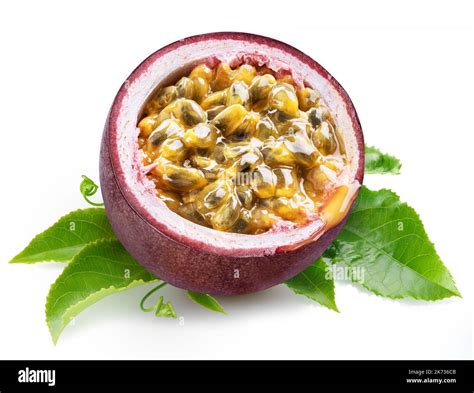 Dark Purple Passion Fruit Half With Seedy Interior Laying On Green Passiflora Leaves On White