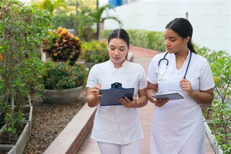 Dos Enfermeras Caminando Por Ahí Revisando Los Datos Del Paciente Foto