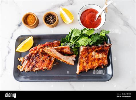 Grilled Pork Ribs On A Ceramic Rectangular Plate With Fresh Tomato