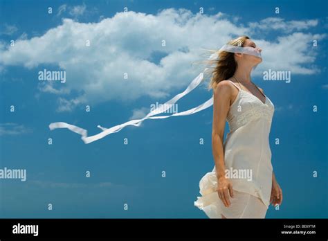 Woman With Ribbon Covering Mouth Ends Of Ribbon Blowing In The Wind