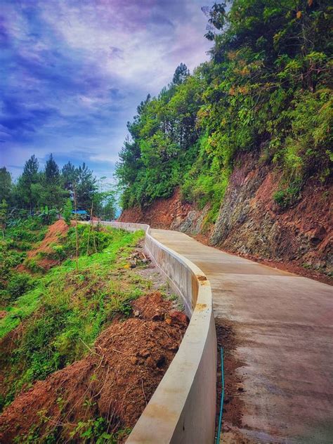 The Newly Built Concrete Road Passes Through The Mountainous Area To
