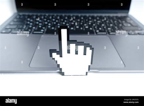 Large Pixelated Hand Shaped Cursor Placed In Front Of A Modern Laptop Technology Related