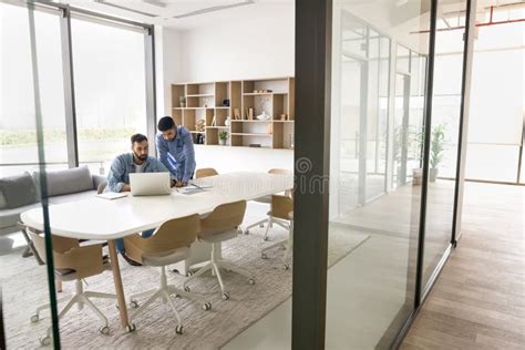 Two Young Multiethnic Businessmen Doing Data Analysis Together Use