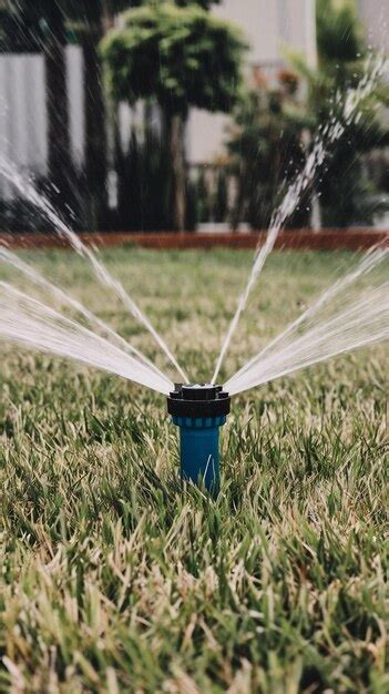 Plastic Sprinkler Irrigating Grass Lawn With Water In Summer Garden Premium Ai Generated Image