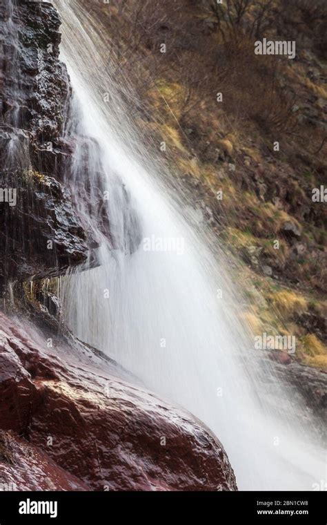 Stunning Close Up Details Of Powerful Waterfall Cascading Down The Red Wet Rocks And Soft