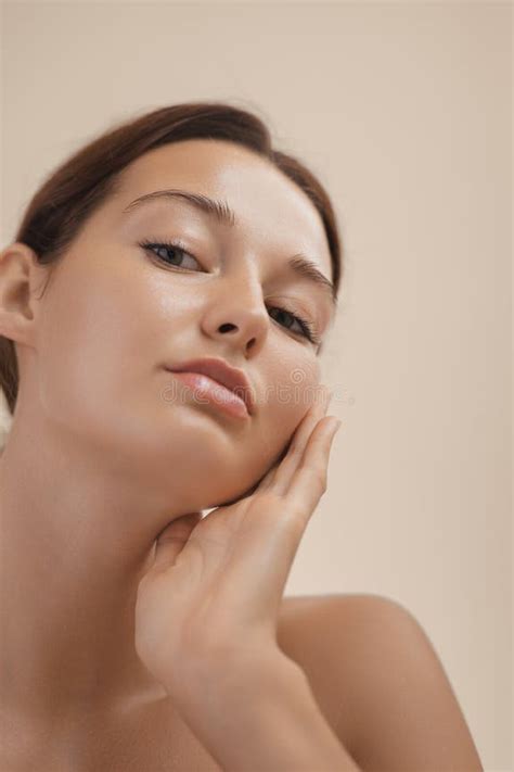 Close Up Beauty Portrait Of Woman With Glowing Skin Touching Face