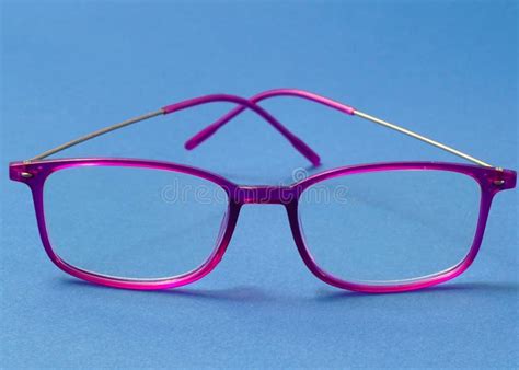 Close Up Of Vivid Pink Plastic Eyeglass Frames On Blue Background