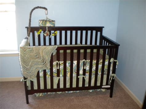 The Crib With A Hand Made Blanket From A Friend That Matches The Colors