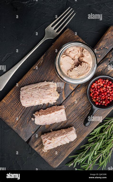 Canned Tuna Fillet Meat In Olive Oil On Black Background Top View