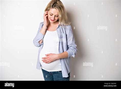 pregnant woman caressing her belly over white background Stock Photo - Alamy