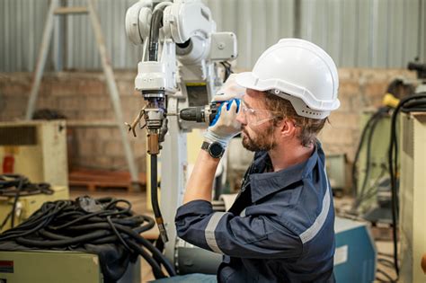 엔지니어 공장 산업은 산업 제조 개념을 위해 자동화 제어 시스템 로봇에 의해 강철 전기를 용접하기 위한 용접 로봇의 안전 유니폼 작업 및 검사 시스템을 착용합니다 Stem