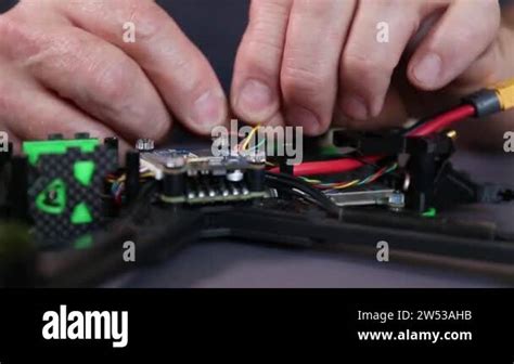 Close Up Of Mans Hands Assembling A Drone From Parts Using Tools Preparing High Speed Racing