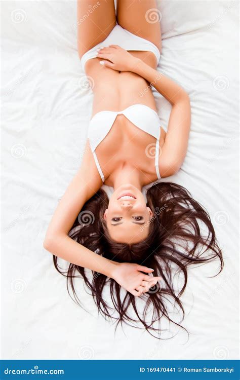 Top View Photo Of Girl With A Beautiful Figure Lying On The Bed Stock