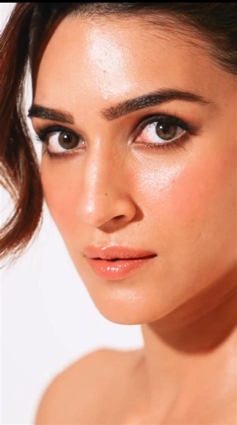 A Close Up Of A Womans Face With Brown Hair And Blue Eyeshadow
