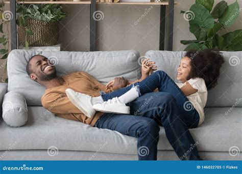 Laughing Funny Father Play With Daughter Lying On Sofa Stock Image Image Of Girl Living