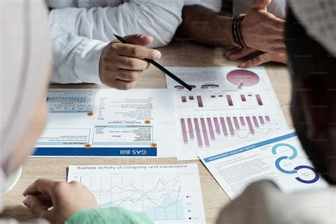 테이블에 앉아 보고서를 분석하는 재무 전문가 그룹 수익 예측 사진 Unsplash의 금융 이미지