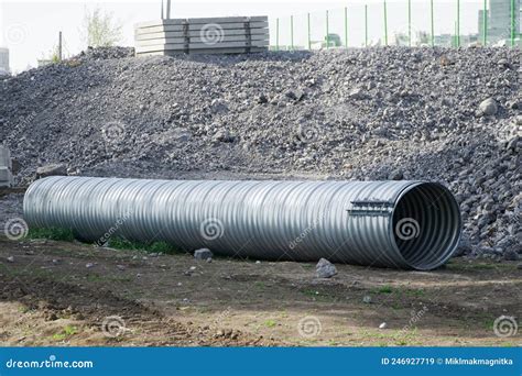 Two Large Corrugated Metal Pipes Prepared For Installation Lie On A