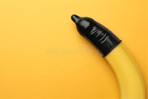 Banana With Condom On Orange Background Top View And Space For Text