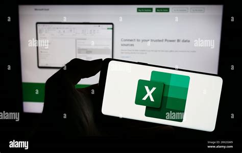 Person Holding Mobile Phone With Logo Of Spreadsheet Editor Microsoft Excel On Screen In Front