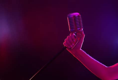 Premium Photo Female Hand Holding A Retro Microphone Against