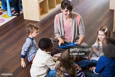 Teacher With Preschoolers In Class Sitting On Floor High Res Stock