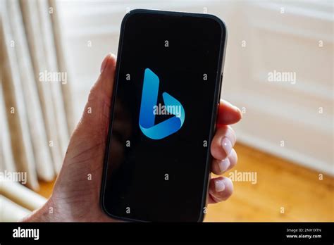 person holds mobile phone showing new microsoft chatgpt openai bing