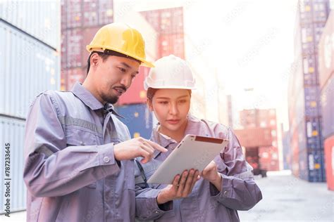 Male And Female Container Yard Worker Loading Containers Box At Commercial Dock Site Group Of