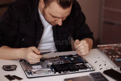 Disassembling A Laptop With A Screwdriver In A Repair Shop Stock Image