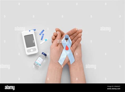 Woman With Awareness Ribbon Glucometer And Insulin On Light Background