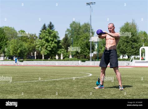 Man Exercising With Kettle Bell Outdoor And Flexing Muscles Muscular
