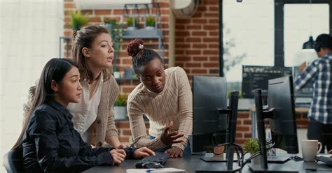 Mixed Team Of Programmers Brainstorming Ideas For New Code Library In Front Of Computer Screens