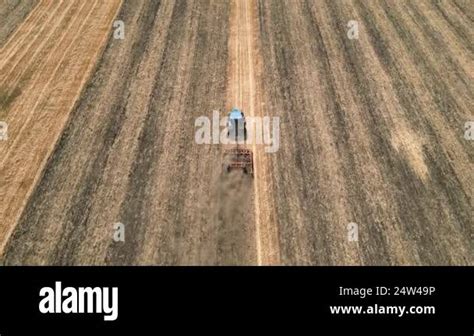 A Large Tractor Diligently Working On A Vast Agricultural Field