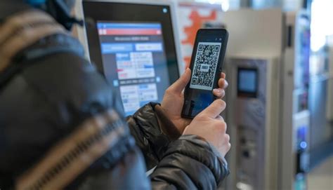 A Customer Using A QR Code On Their Smartphone To Verify Their Identity At A Selfservice Kiosk