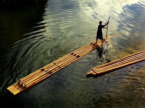 A Boatman Paddles His Bamboo Raft Along The River At Wawa Dam