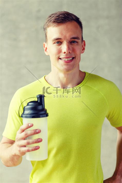 拿着蛋白质奶昔瓶的微笑男人高清摄影大图 千库网