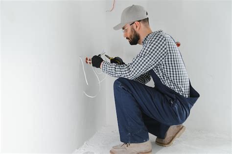 Premium Photo Electrician Installs Socket Boxes On The Wall And Puts A Putty On Them