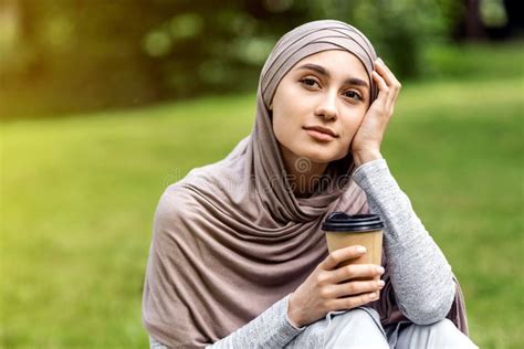 Dreamy Arab Girl Sitting Alone At Park Drinking Coffee Stock Image
